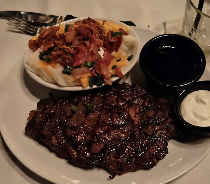 A ribeye with perfect grill marks alongside a loaded baked potato. Some relationships were just meant to be—like beef and fire.