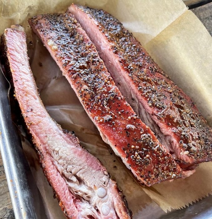 Ribs with that perfect pink smoke ring—the kind that make you temporarily consider giving up silverware forever and embracing your inner caveman.