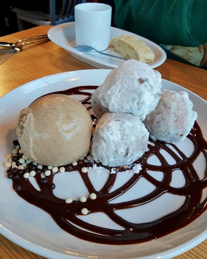 These aren't your carnival donuts – they're cloud-like pillows of sweetness dancing on a chocolate canvas. Dessert nirvana has been achieved.