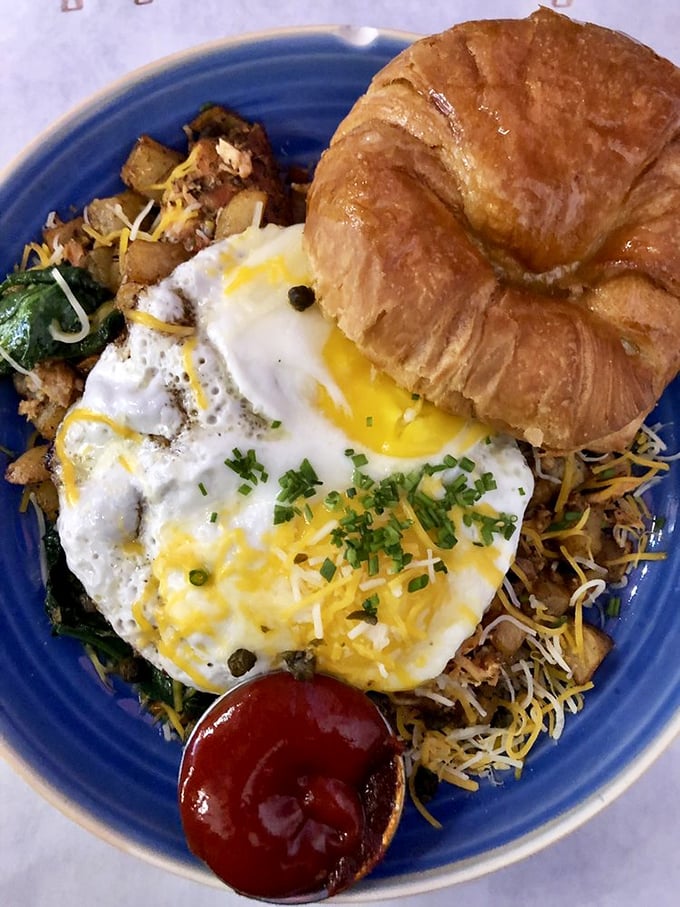 Sunny-side perfection meets buttery croissant in a breakfast romance that'll have you planning tomorrow's return visit before you've finished today's meal.