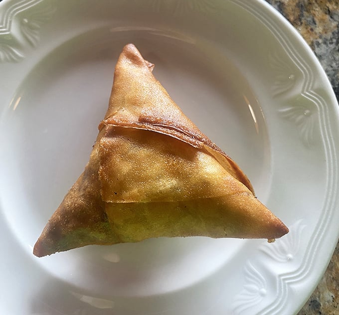 The sambusa triangle—crispy, flaky, and filled with savory goodness. Like an empanada that went to graduate school and came back worldly and sophisticated.