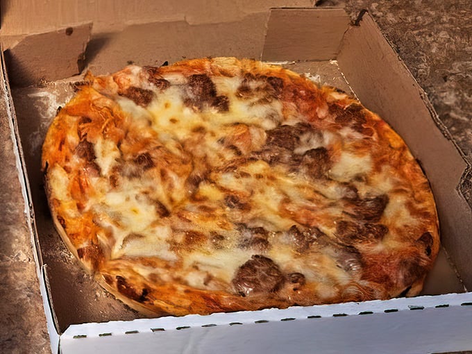 Melted cheese cascading over sausage and sauce—this isn't just dinner, it's a warm hug in circular form.