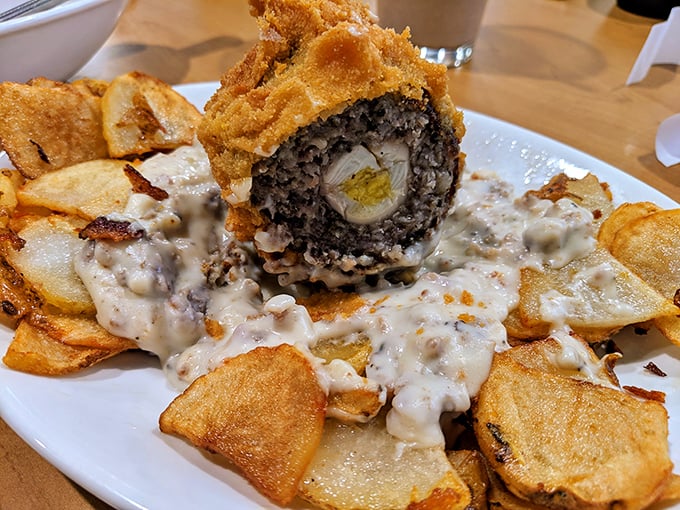 Culinary engineering at its finest – a Scotch egg nestled on homestyle potatoes with gravy that would make your grandmother both jealous and proud.