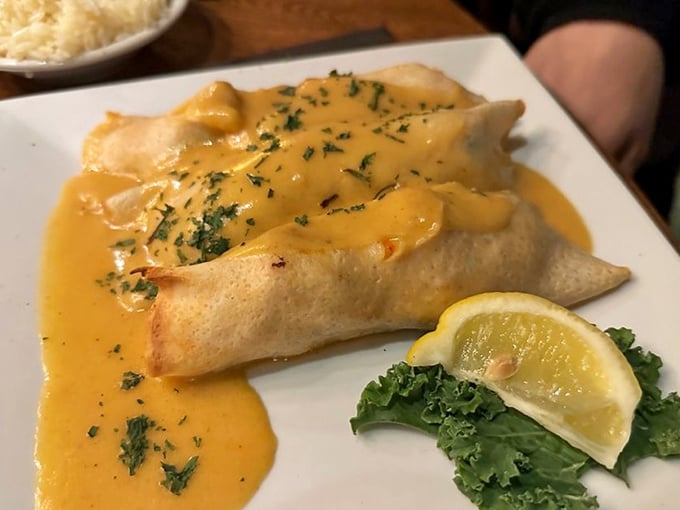 Seafood crepes that whisper "oui, oui" to your taste buds. Delicate wraps cradle ocean treasures beneath a sunshine-yellow sauce.