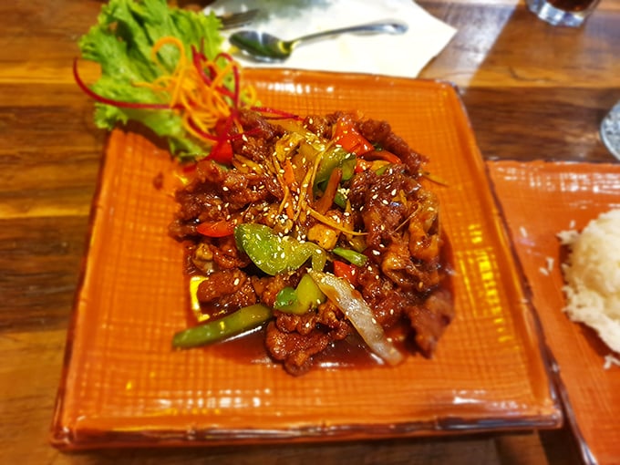 The sesame duck arrives like a celebrity—dramatically plated, glistening with sauce, and surrounded by an entourage of colorful vegetables.