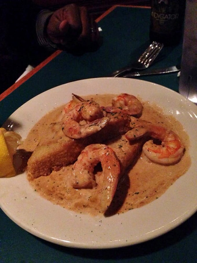 Shrimp swimming in creamy sauce with a slice of bread for sopping—because letting any of that liquid gold go to waste would be a culinary crime.