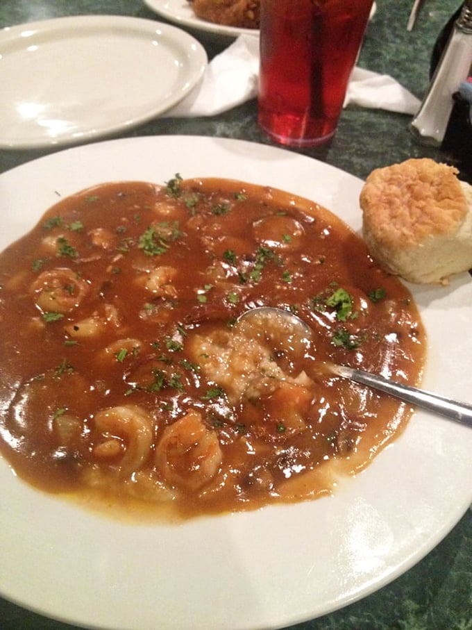 Shrimp and grits swimming in savory gravy with that perfect biscuit standing by. It's not just breakfast; it's an edible Southern hug.