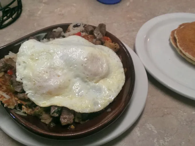 A hearty skillet topped with a sunny-side-up egg—proof that breakfast is the most important meal of the day and possibly the most delicious.