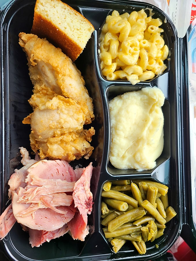 The to-go container might be modern, but what's inside is timeless—fried chicken, ham, and sides that make you want to hug the cook.