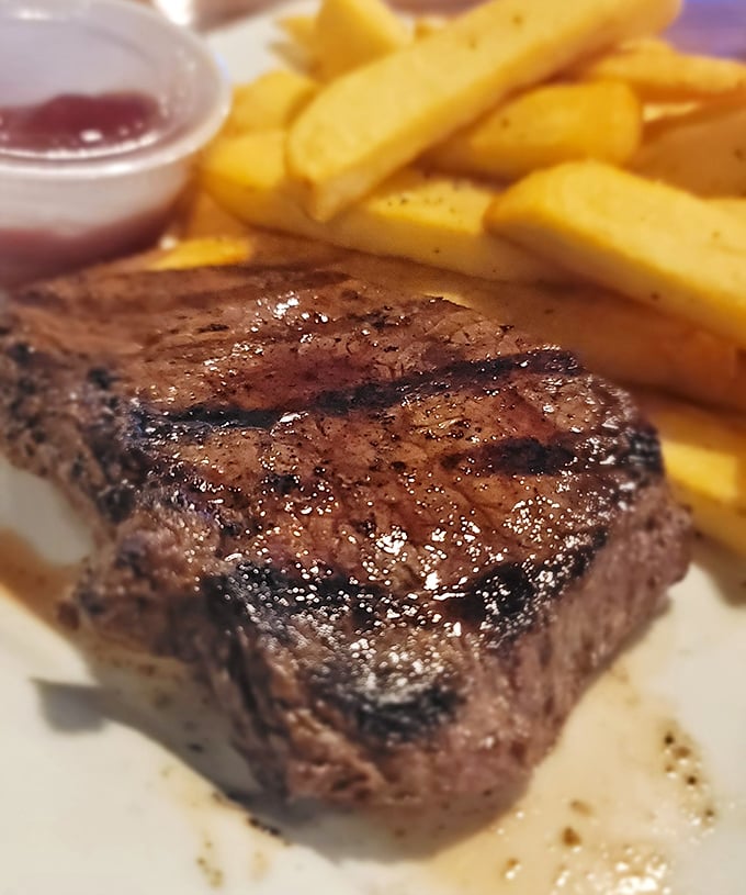 This isn't just any steak – it's the kind that makes you pause mid-conversation, close your eyes, and momentarily forget your dinner companions exist.