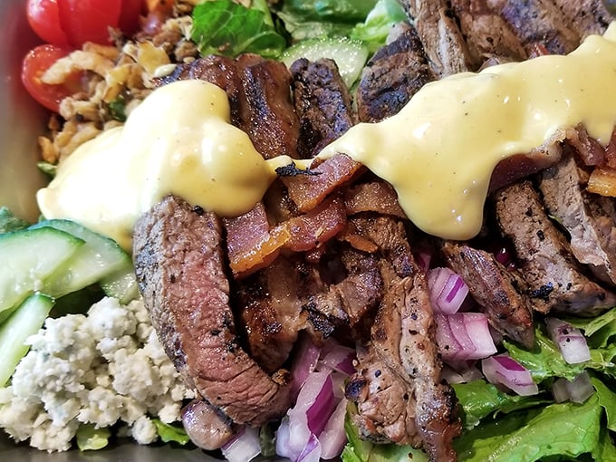 Tender slices of perfectly seared steak lounging atop fresh greens with a sauce so good you'll contemplate drinking it straight. No judgment here.