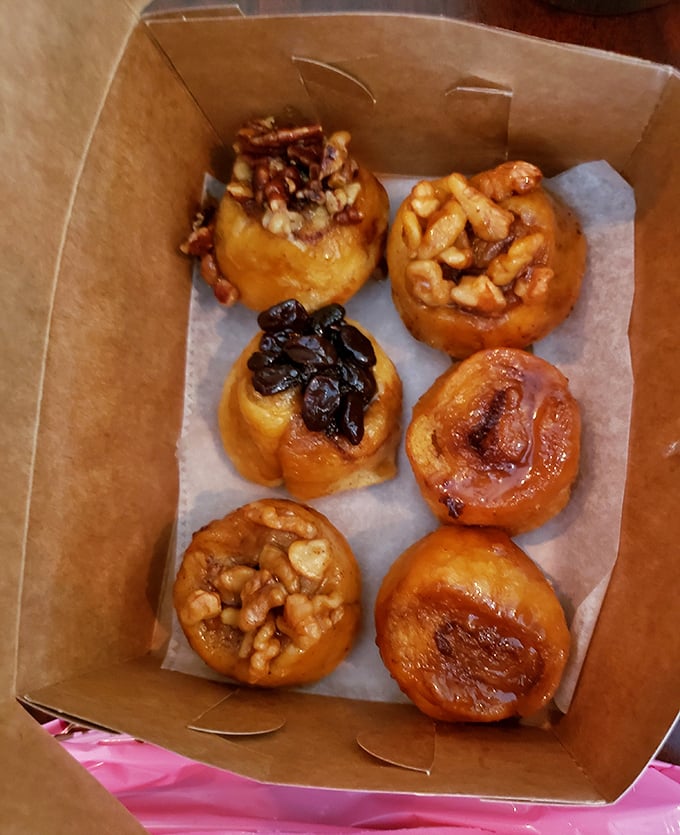 Sticky buns that glisten with caramel promise, each one a spiral galaxy of sweetness with planetary clusters of nuts and raisins throughout.