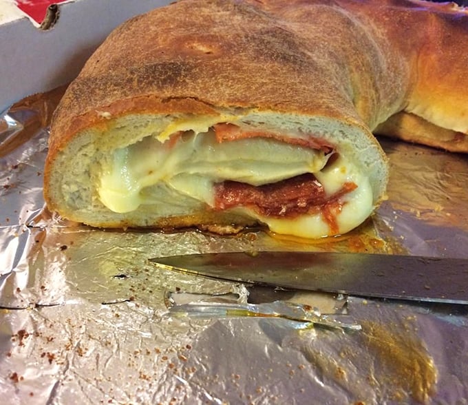 The cross-section reveals the true artistry—a perfect spiral of meat, cheese, and sauce that would make Leonardo da Vinci weep with geometric joy.