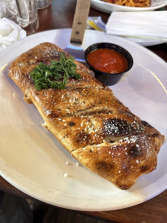 This isn't just a stromboli—it's edible architecture with a golden-brown dome that would make Michelangelo weep with joy.