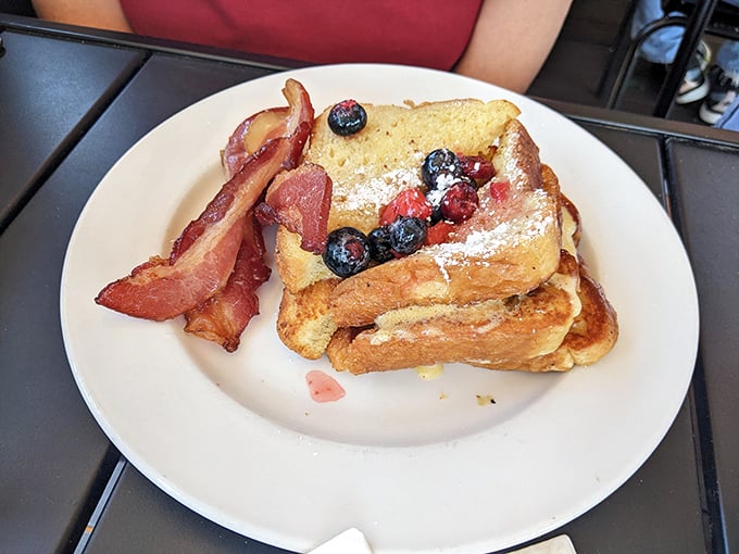 French toast that's had an existential crisis and emerged better for it—stuffed, berry-topped, and flanked by bacon sentinels.