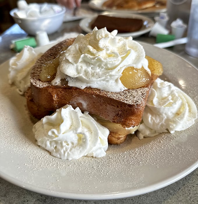 This isn't just French toast—it's a pillowy challah creation that's having a whipped cream party. Breakfast or dessert? Yes, please.