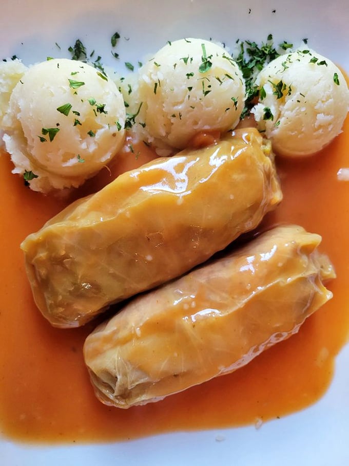 Stuffed cabbage rolls bathing in tomato sauce with potato dumplings standing guard. Comfort food that hugs you from the inside.