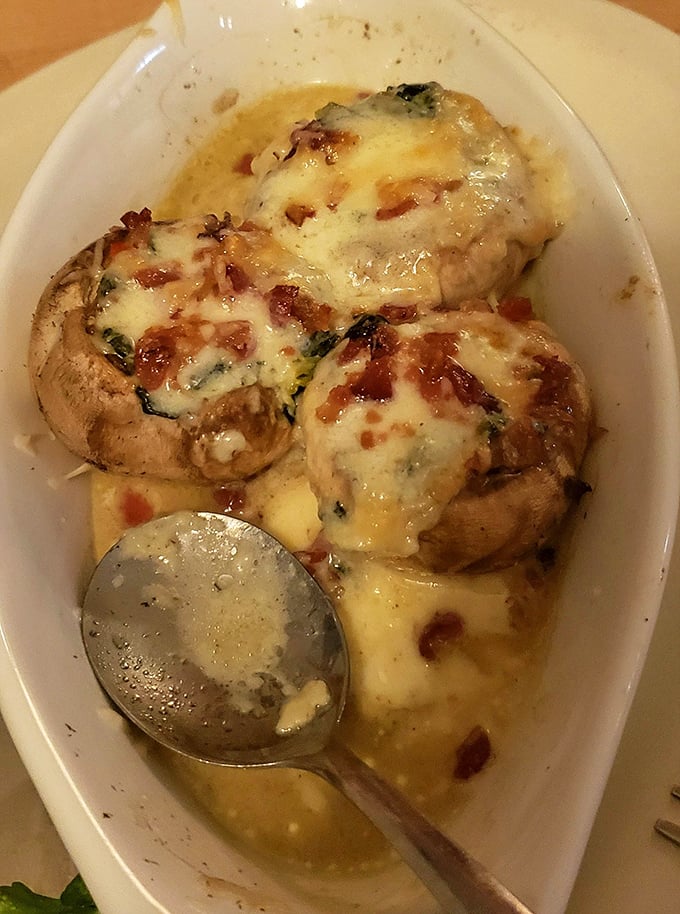 Stuffed mushrooms swimming in buttery goodness—like little flavor submarines delivering payloads of cheese and bacon to your taste buds.