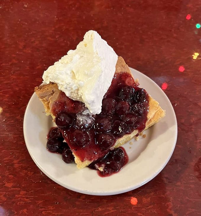 Berry pie that strikes the perfect balance between homestyle comfort and restaurant finesse. That whipped cream isn't just a topping—it's the crown jewel.