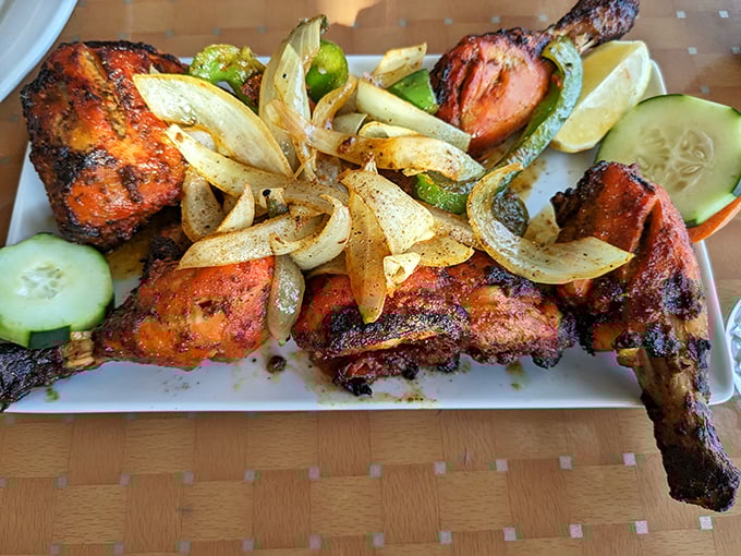 Tandoori chicken with its signature crimson hue and charred edges arrives with grilled vegetables and cucumber – proof that simplicity, when done right, is magnificent.