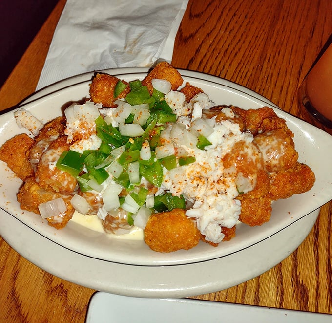 These aren't your freezer aisle tater tots—they're crispy golden nuggets crowned with cheese and green onions that make adulting suddenly worthwhile.