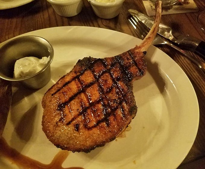 This isn't just a pork chop—it's a monument to meat, grilled with perfect crosshatch marks that should be in a museum of culinary art.
