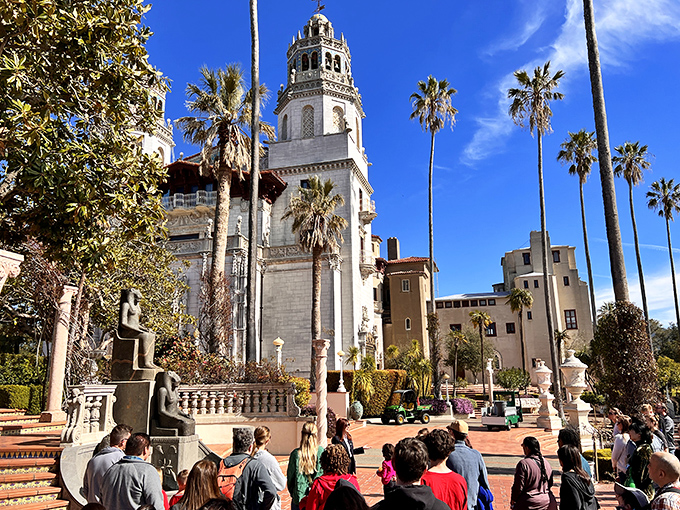 Palm trees and bell towers—California's version of "old money." The tour groups gather below like pilgrims at an altar of excess and architectural audacity.