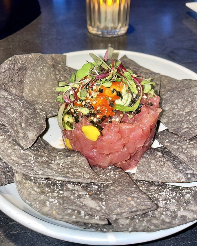 Tuna tartare that's dressed better than most people at formal events. Those black chips aren't just for show—they're the perfect delivery system. 
