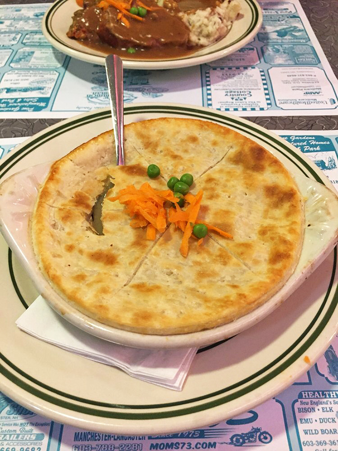 Pot pie perfection—golden, flaky crust hiding a steamy treasure of savory filling. The carrots and peas peeking through are just showing off.