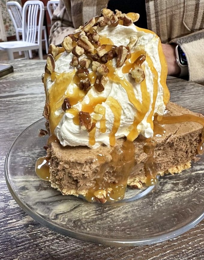 Caramel cascades down whipped cream mountains atop this turtle cheesecake – proof that sometimes the best architecture isn't in buildings but on dessert plates.