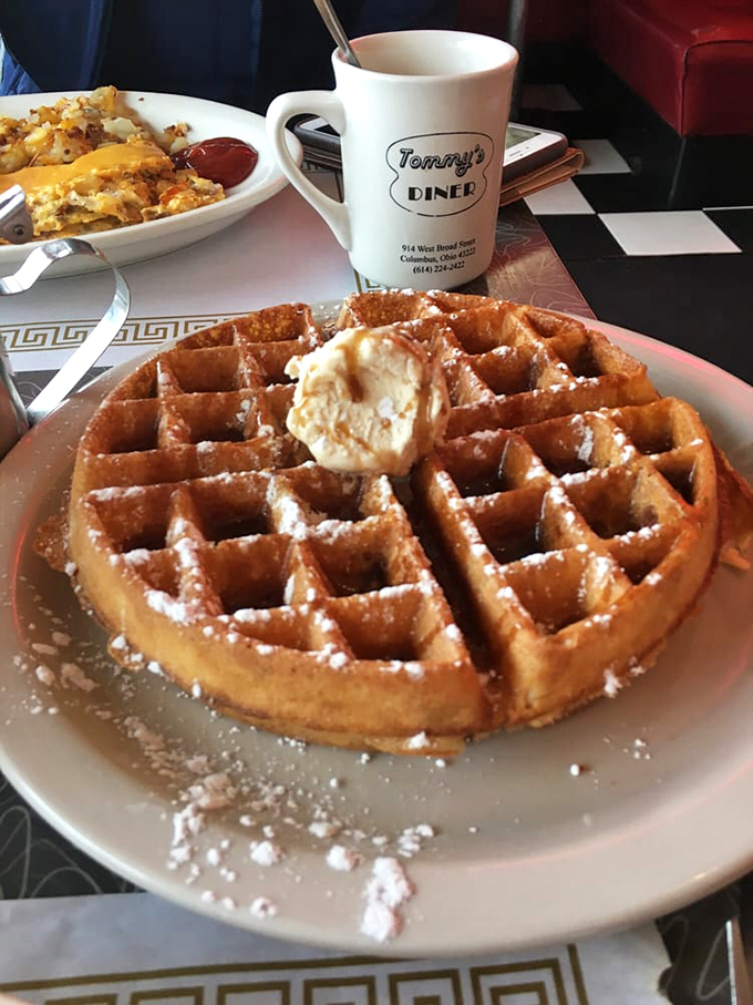 This waffle isn't playing hard to get—it's already dressed in powdered sugar and waiting for you with a pat of butter melting seductively.