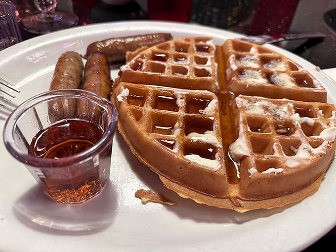 These golden waffles aren't just breakfast—they're edible geometry, perfectly engineered to hold pools of maple syrup in their square reservoirs.