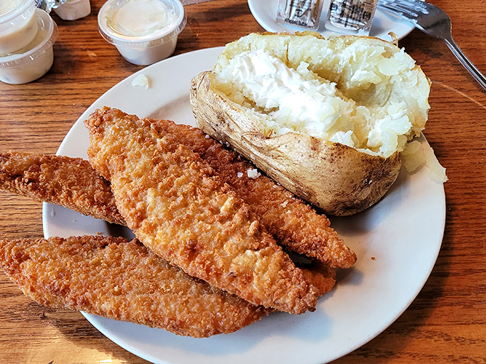 Golden-crusted walleye fillets beside a loaded baked potato—proof that sometimes the simplest pleasures are the most satisfying.