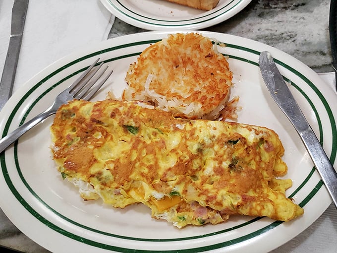 This isn't just an omelet—it's a golden envelope stuffed with morning promises and hash brown dreams. The kind of plate that makes you plan your next visit.