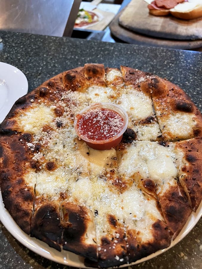 A cheese pizza with edges kissed by fire and a crust that's part cloud, part crunch—the wood-fired difference isn't just marketing, it's mathematics.