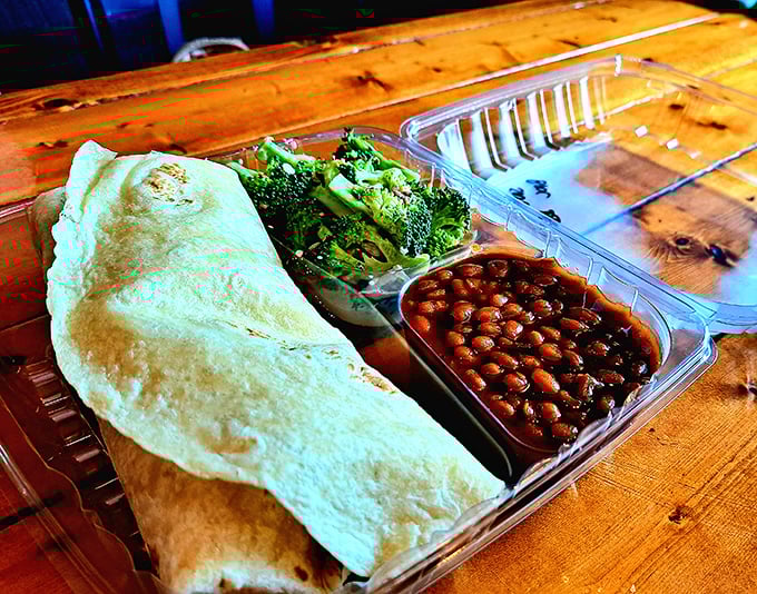 That wrap isn't just holding meat—it's cradling barbecue treasure alongside fresh broccoli and beans that somehow make you feel virtuous while indulging.