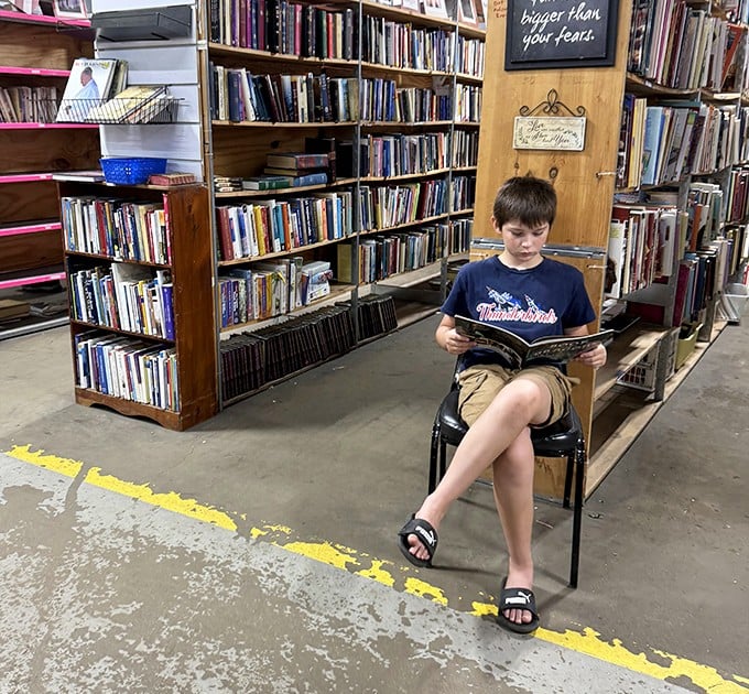 A young reader lost in another world, proving that even in our digital age, the magic of turning physical pages still captivates. The next generation of bibliophiles is safe.