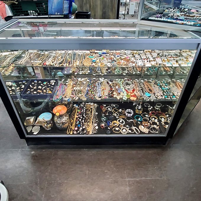 The jewelry counter sparkles with possibility—one person's forgotten accessory becomes another's statement piece in this treasure chest display.