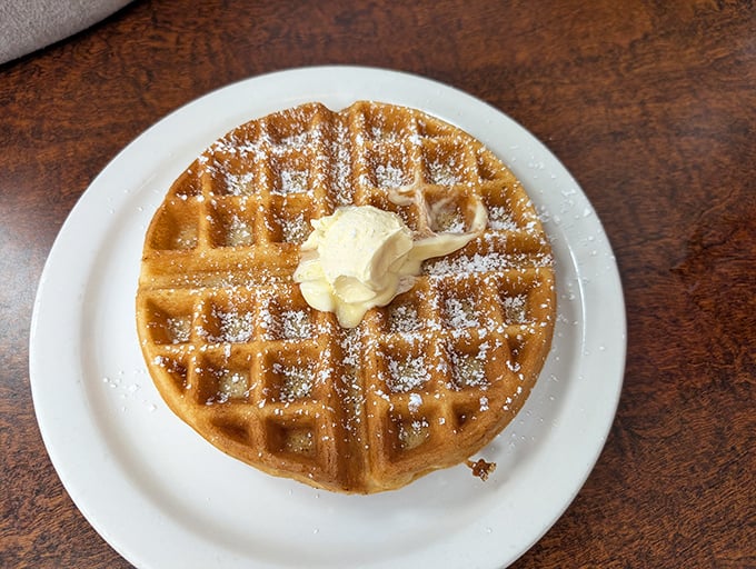 This Belgian waffle doesn't need a passport to impress—just powdered sugar snow and a butter pat melting like a summer romance.