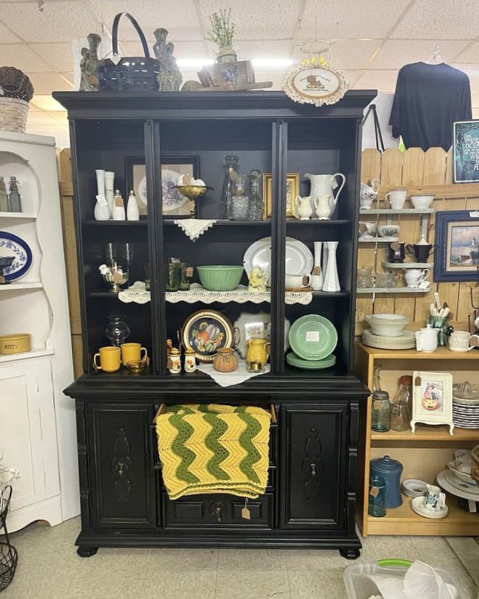 This stately black cabinet doesn't just display dishes – it showcases domestic history with each carefully arranged teacup and jadeite plate.