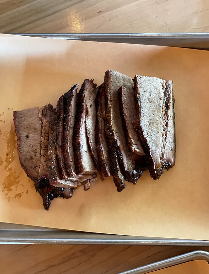 Brisket sliced with the precision of a surgeon's hand. That pink smoke ring isn't just pretty – it's the barbecue equivalent of a Michelin star.