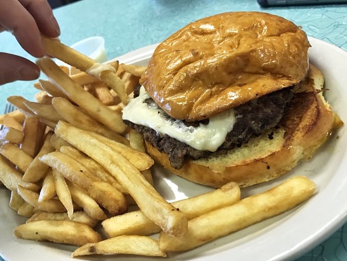 The burger and fries combo—America's most reliable relationship. This hefty specimen has all the hallmarks of a classic diner masterpiece.