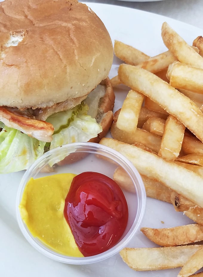 This isn't some fancy gastropub's "deconstructed" burger—it's the real deal, with crispy fries and that perfect half-and-half condiment setup that says "we get you."