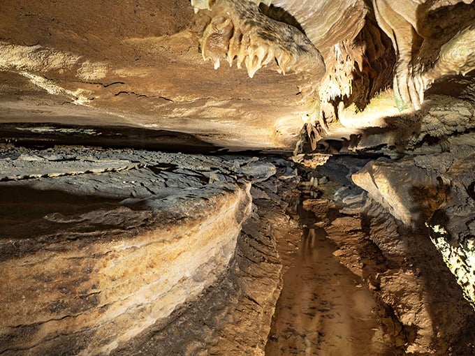 Stalactites reaching down like nature's chandeliers, illuminating a pathway that feels like walking through Earth's own art gallery.