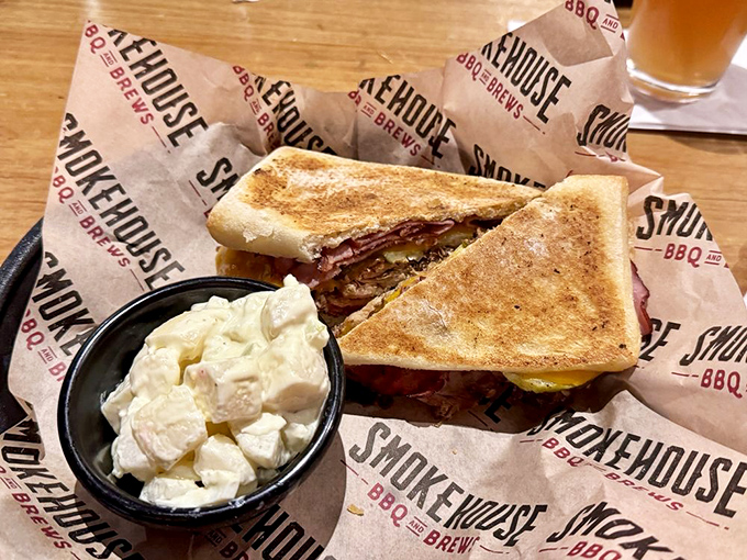 This isn't just a sandwich; it's architecture – layers of smoky meat and melty cheese between perfectly toasted bread, with potato salad standing guard.