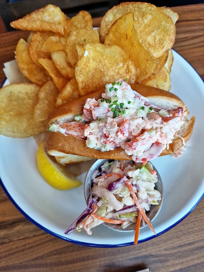 The lobster roll—that perfect New England export—arrives overflowing with sweet meat, alongside house-made chips that deserve their own fan club.