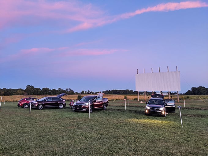 That magical twilight moment when cars find their perfect spots and the sky turns cotton-candy pink, signaling the start of drive-in magic.