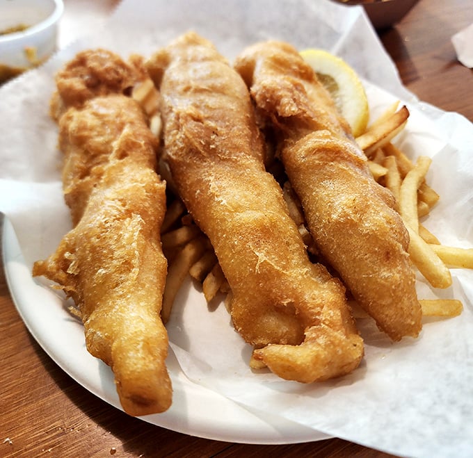 Golden-battered fish that shatters with each bite, paired with fries that somehow stay crisp even as you contemplate ordering seconds.