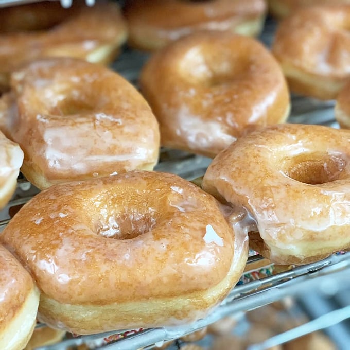 Glazed donuts in their natural habitat – glistening under bakery lights. These aren't just donuts; they're edible sunshine with a side of nostalgia.