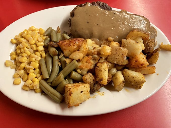 The home fries aren't just a side dish, they're the main event – golden-brown cubes sharing the spotlight with perfectly seasoned vegetables and gravy-smothered meat.